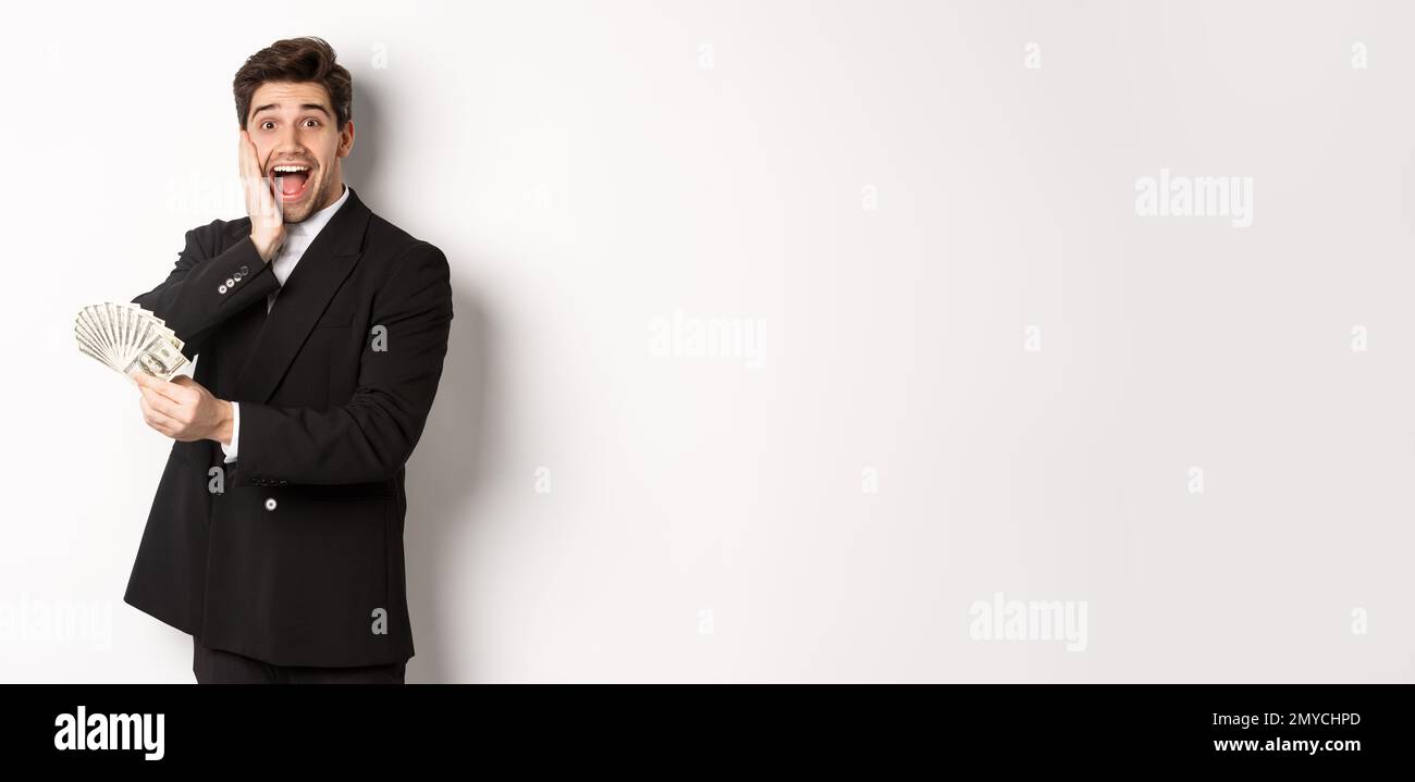 Image of rich and happy man in black suit, winning prize, holding money ...