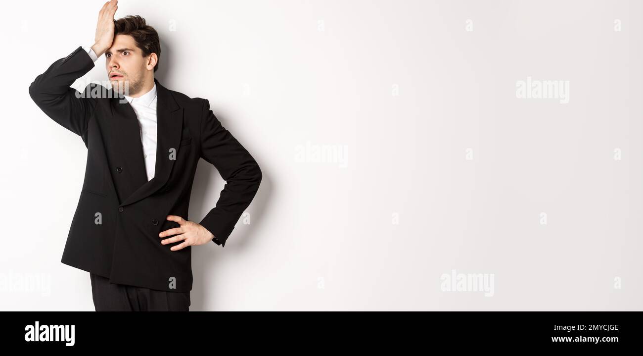 Portrait of shocked and distressed businessman in black suit, slap ...