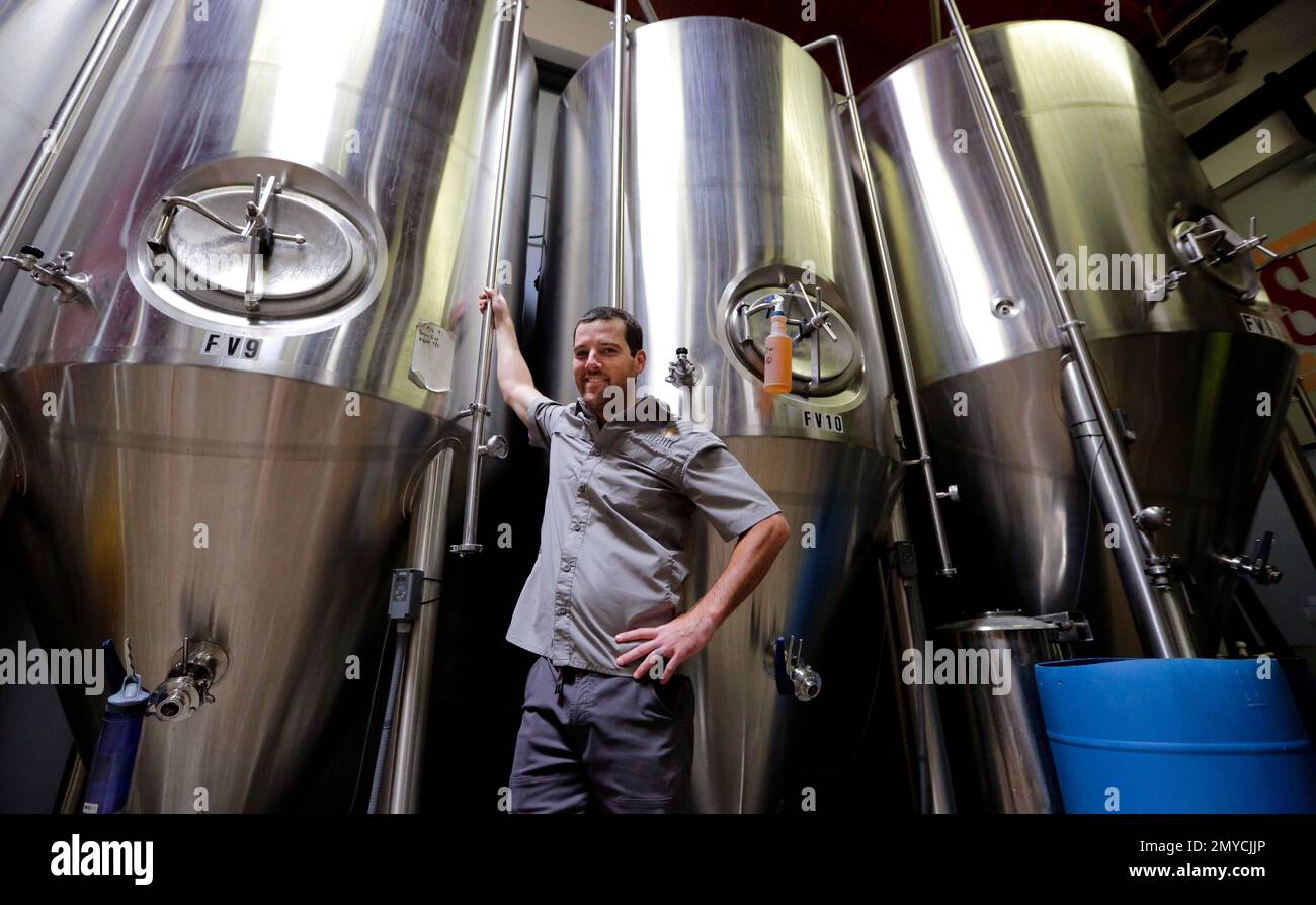 Hops & Grain owner Josh Hare poses by fermentation tanks at his brewery ...