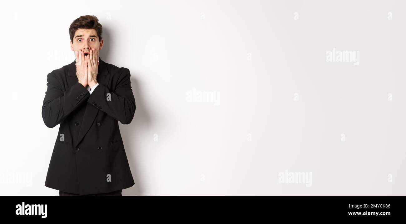 Image of concerned and scared man in black suit, gasping and looking ...