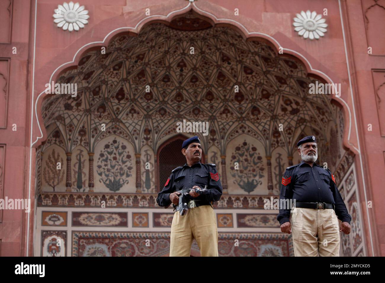 Pakistani police officers stand guard at the historical Badshahi mosque ...