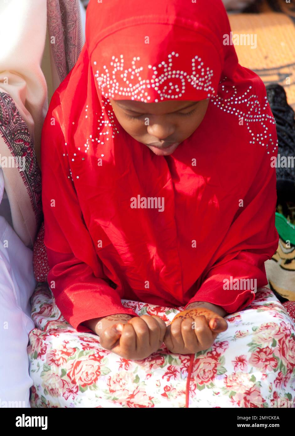 A Kenyan Muslim girl attends the Eid al-Fitr prayers outdoors as ...