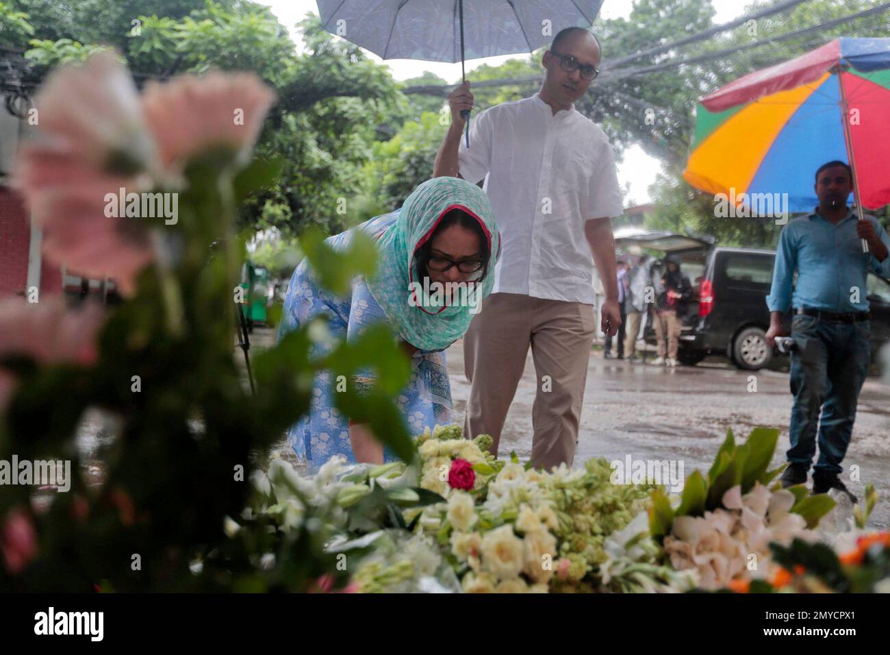 People offer flowers to pay their respects to the victims of the attack ...