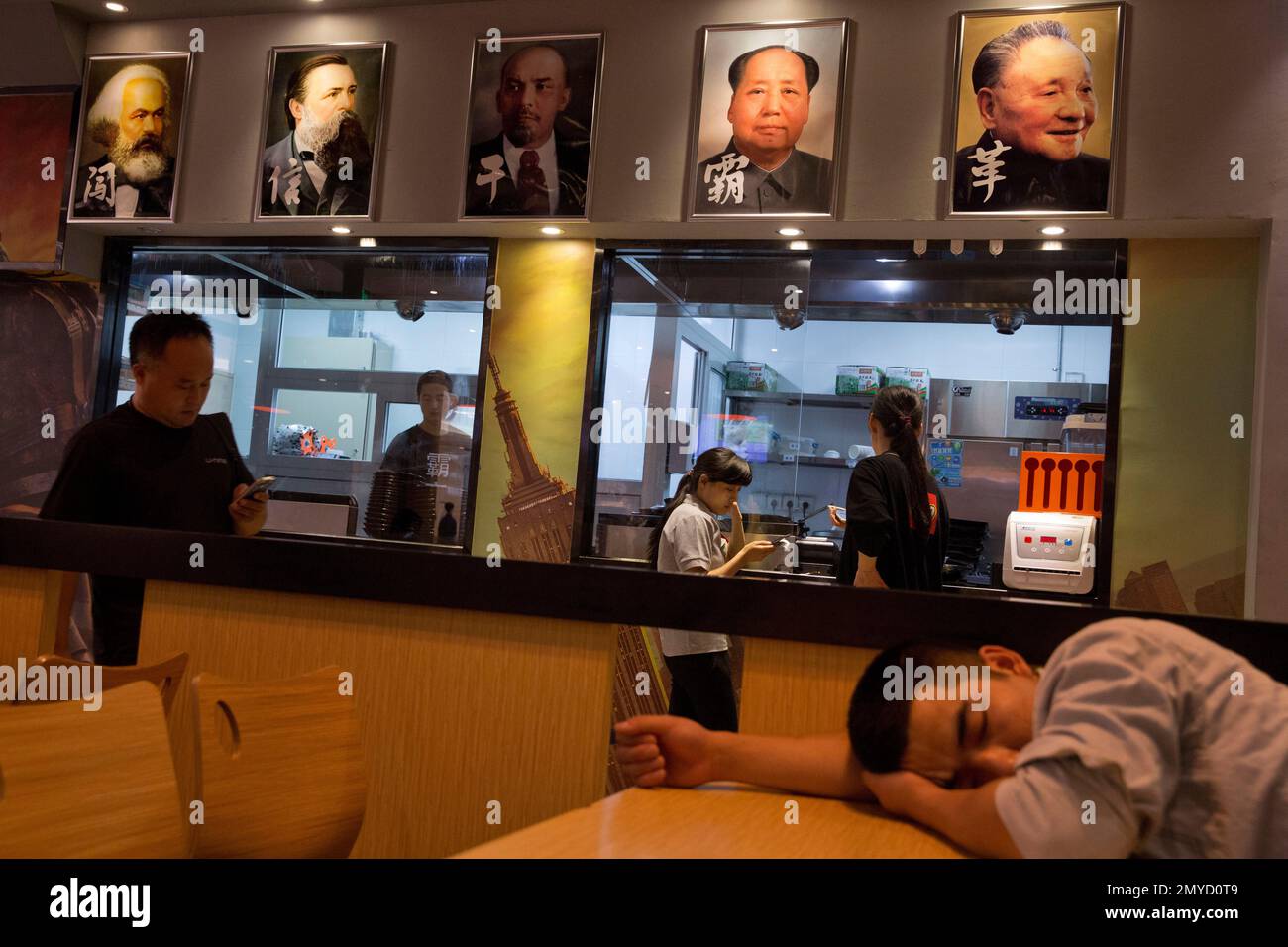 A man sleeps near the Funiutang beef noodle restaurant displaying ...