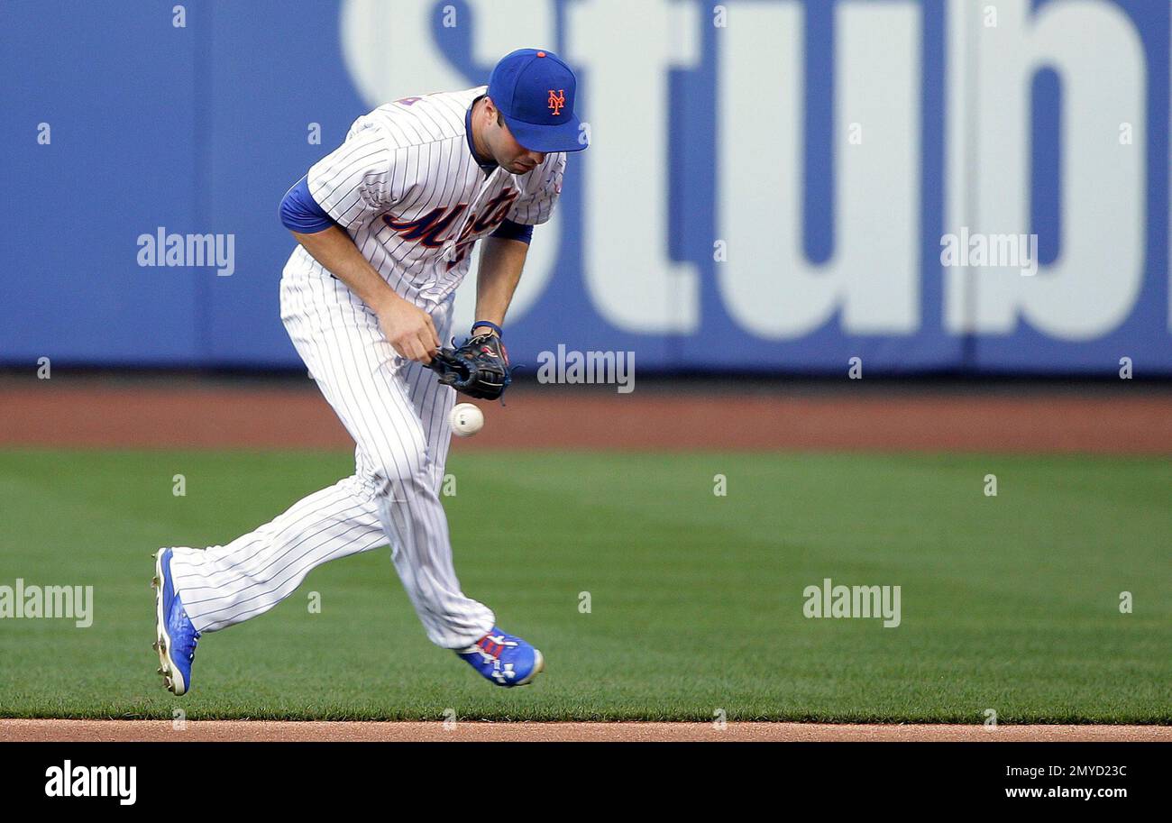 New York Mets second baseman Neil Walker mishandles a ground ball hit ...