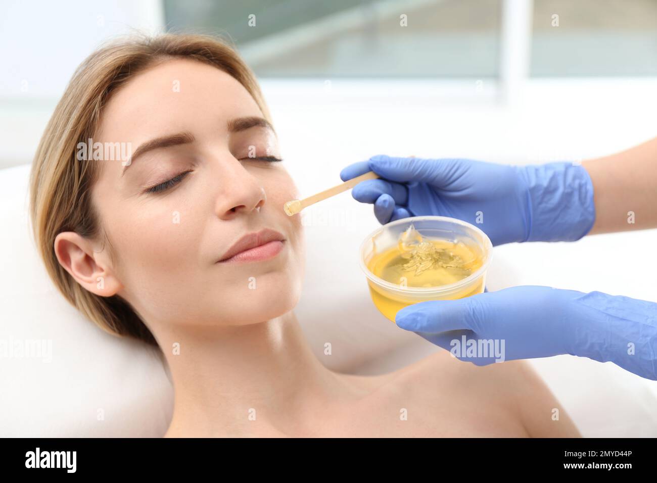 Beautiful woman getting wax epilation of face in salon Stock Photo - Alamy