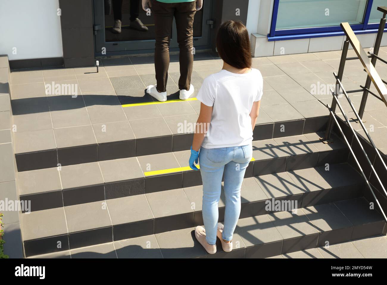 People keeping social distance in line on stairs outdoors. Coronavirus ...