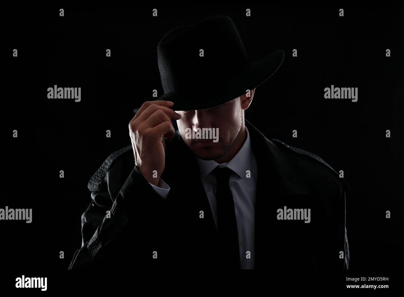 Old fashioned detective in hat on dark background Stock Photo - Alamy