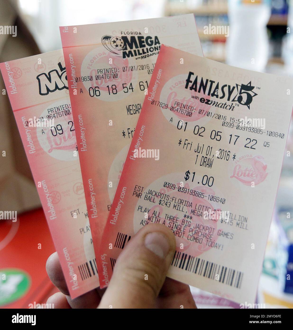 A customer shows his lotto tickets purchased at a grocery store, Friday ...