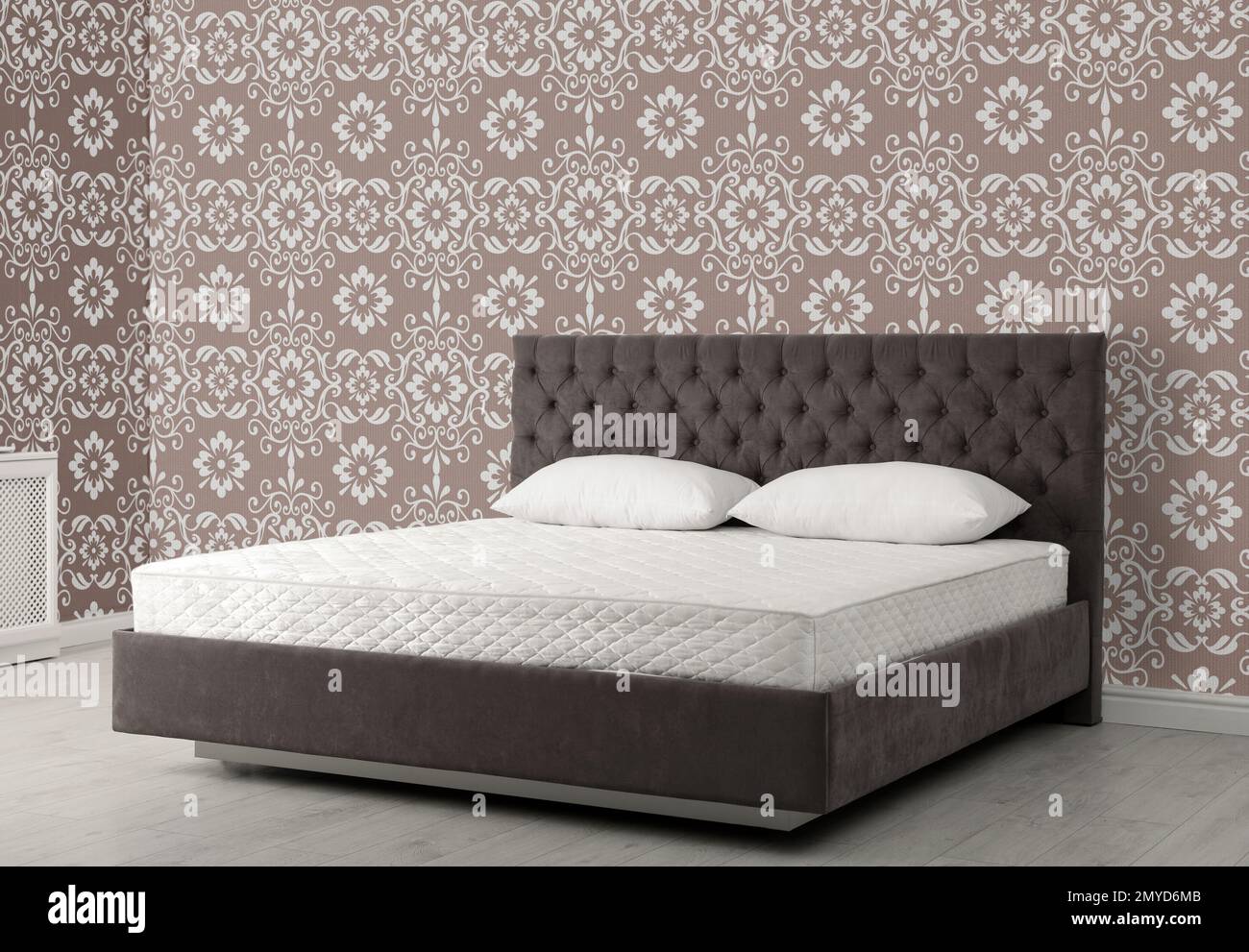 Large bed near patterned wallpapers. Interior design Stock Photo - Alamy