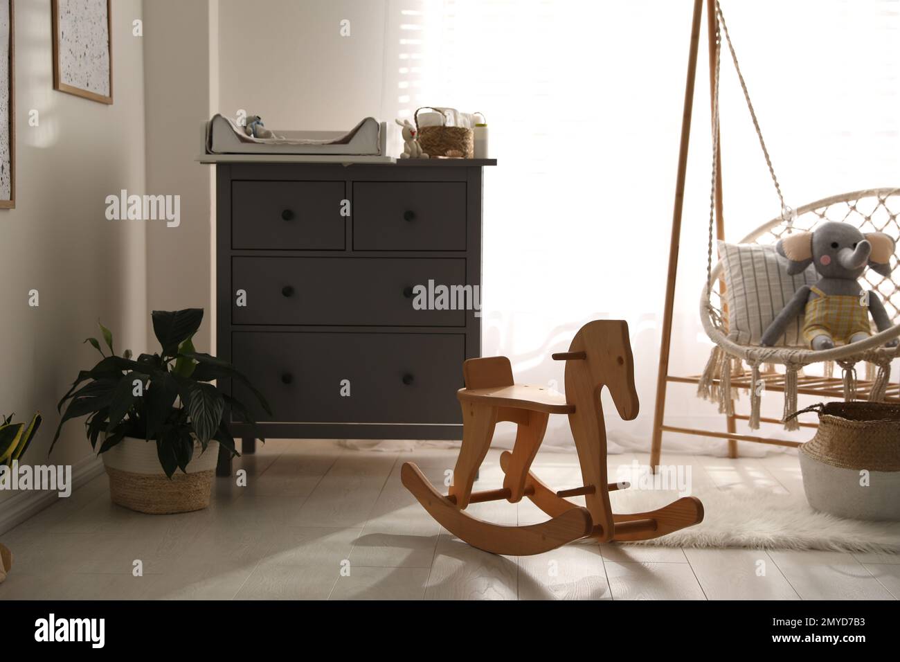 Baby room interior with modern changing table and wooden swing Stock ...