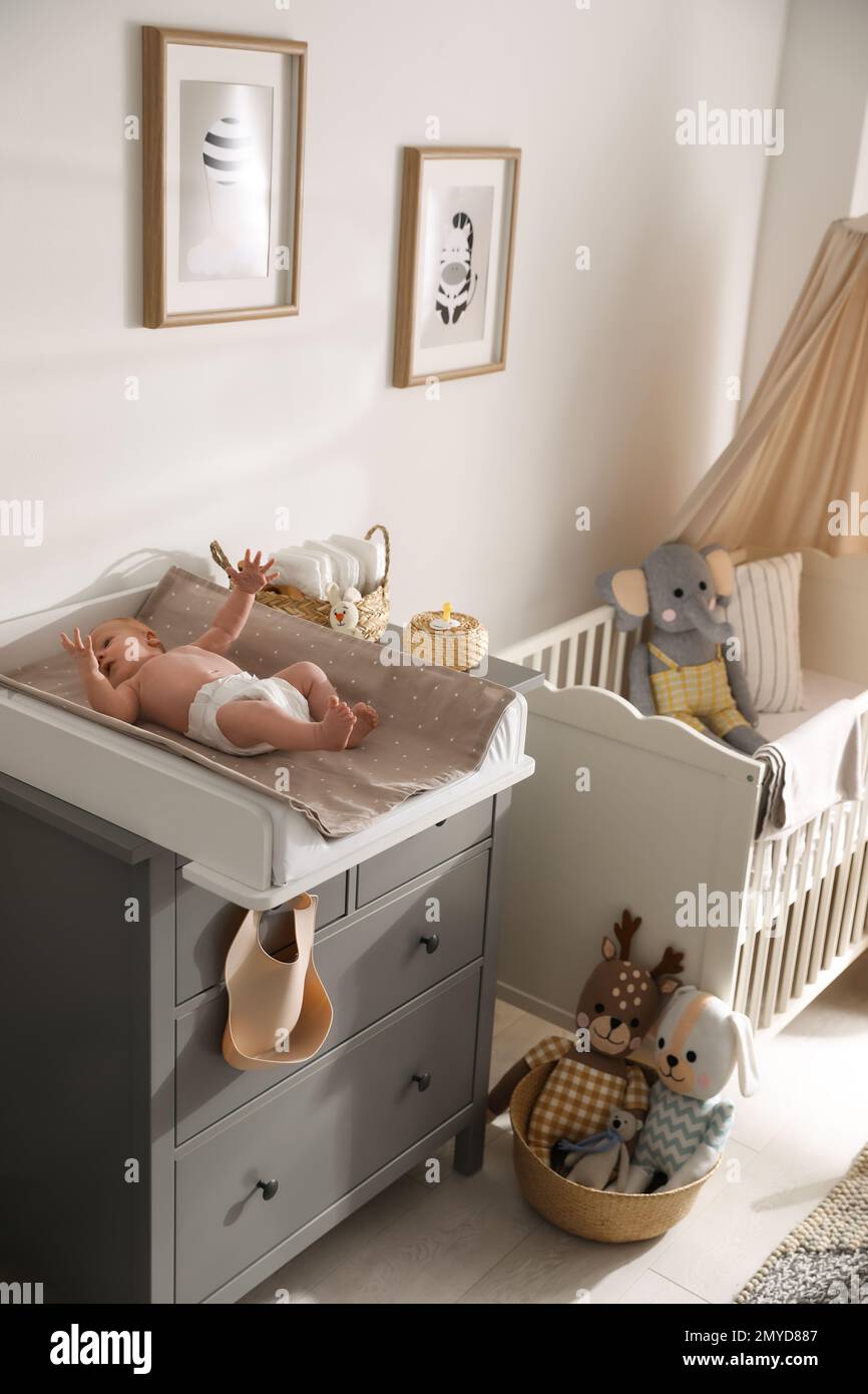 Cute little baby on changing table in room Stock Photo - Alamy