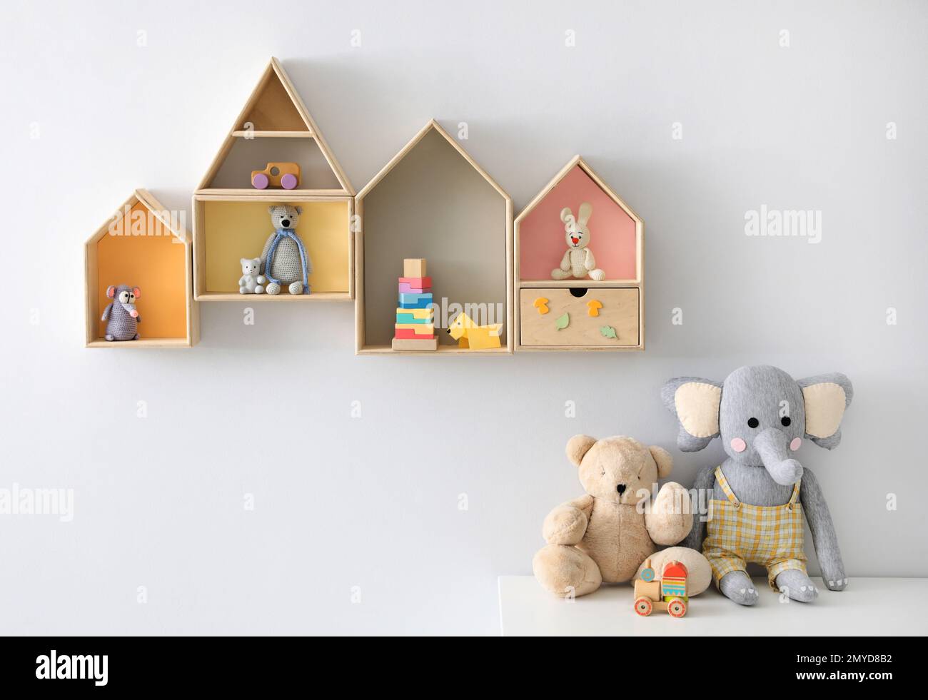 House shaped shelves and table with toys in children's room. Interior ...