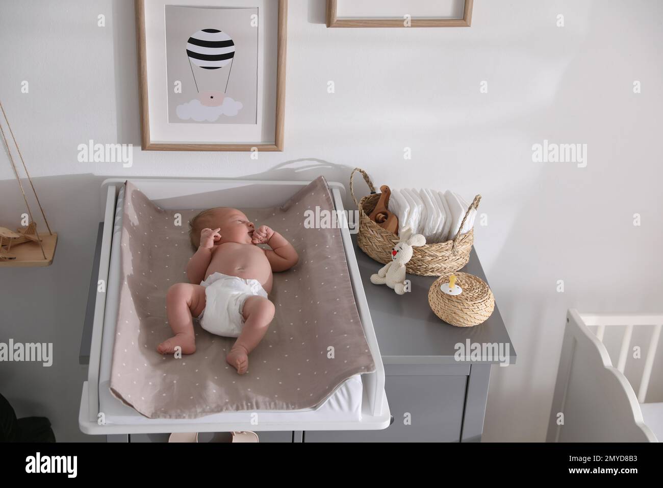 Cute little baby on changing table in room Stock Photo - Alamy