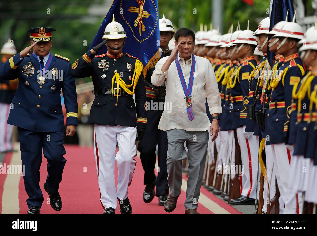 Philippine President Rodrigo Duterte, right, salutes beside Police ...
