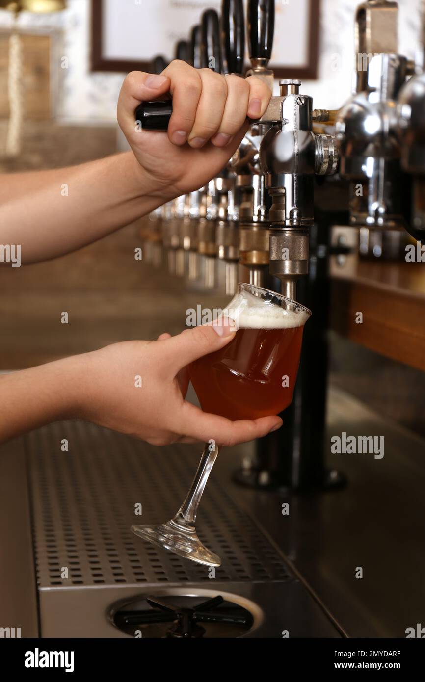 Bartender pouring fresh beer into glass in pub, closeup Stock Photo - Alamy