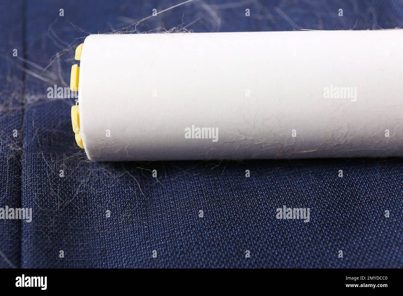 Removing hair from blue fabric with lint roller, closeup Stock Photo ...