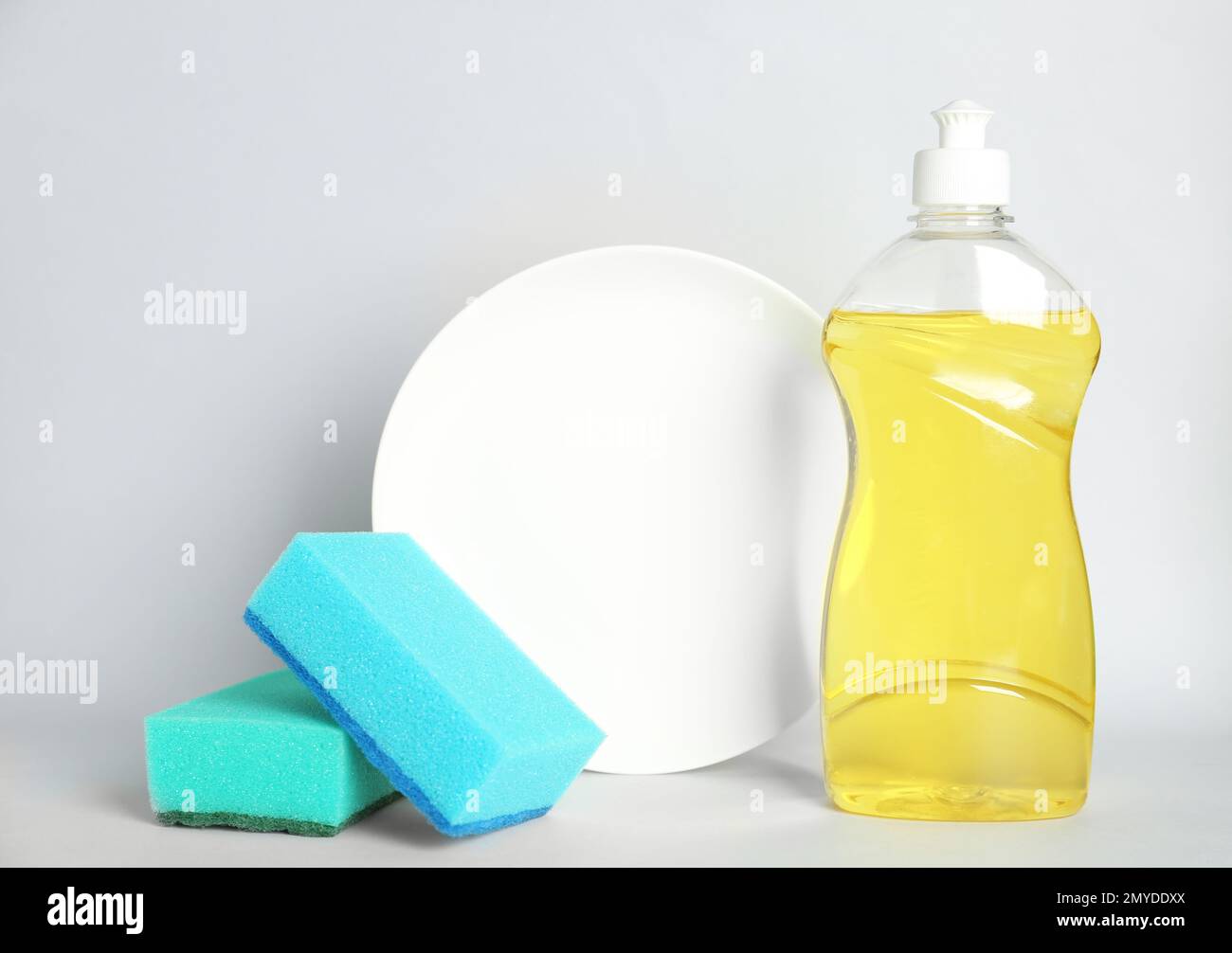 Detergent, plate and sponges on light background. Clean dishes Stock ...