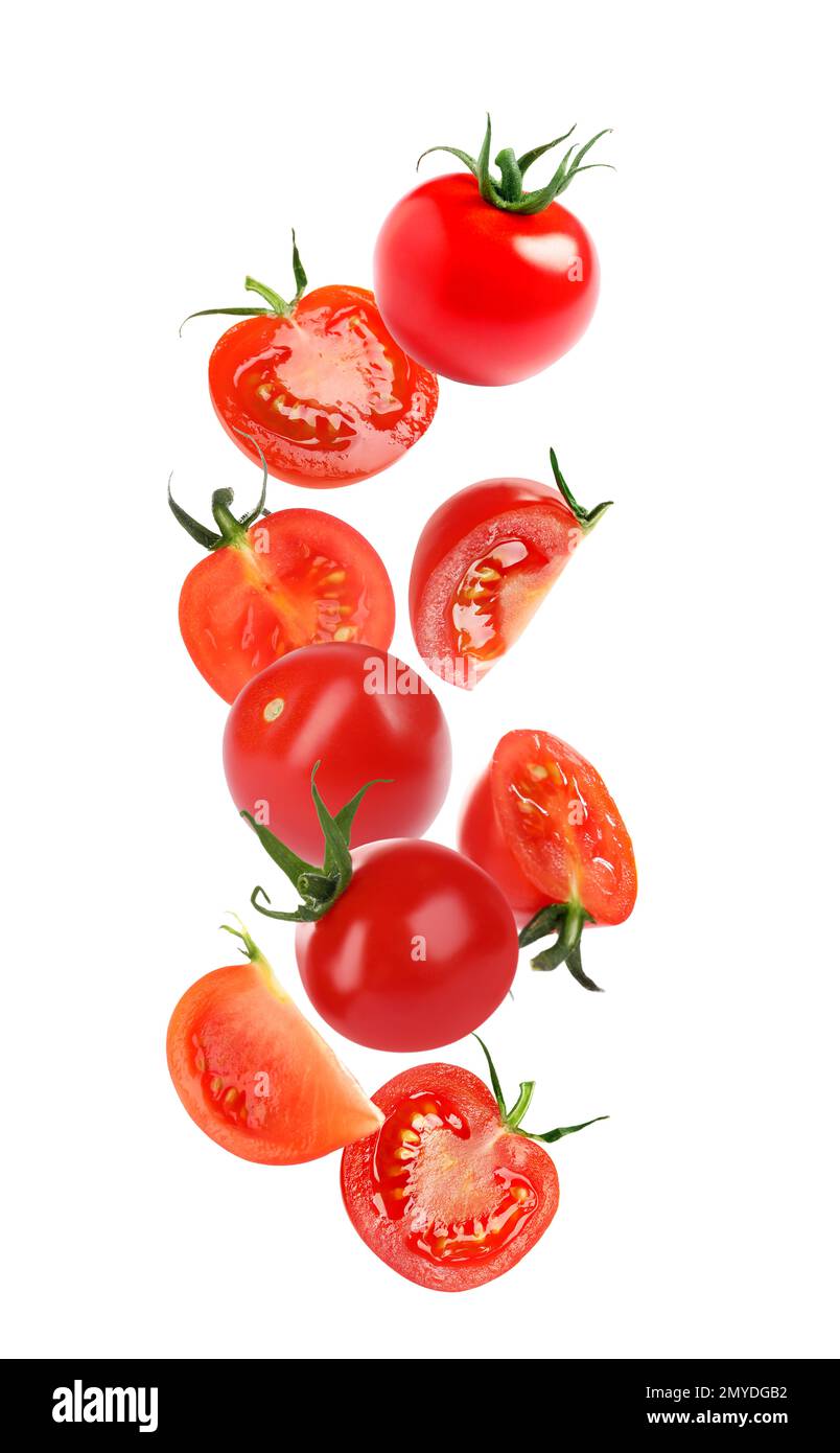 Many cut and whole tomatoes falling on white background Stock Photo - Alamy
