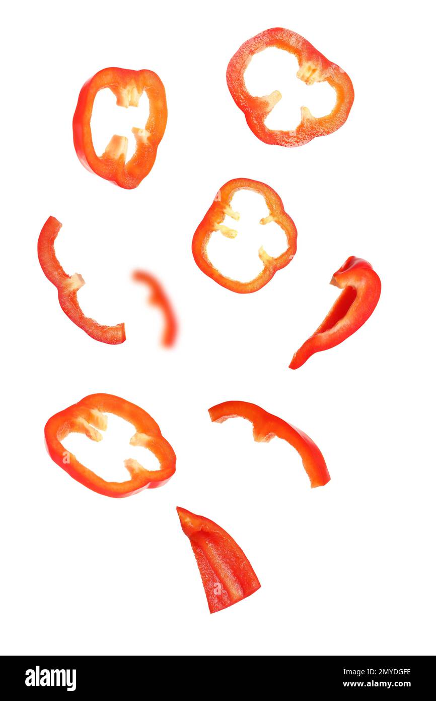 Red bell pepper slices falling on white background Stock Photo - Alamy