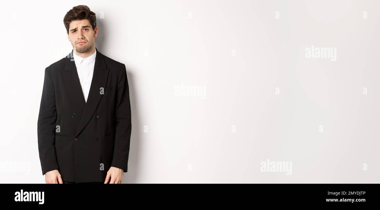 Image of gloomy and sad handsome male model in black suit, frowning and ...