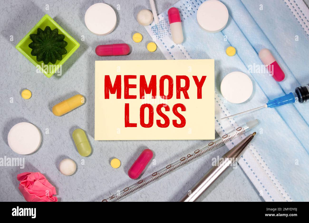 On a light wooden table there is a stethoscope, a pen and a sheet of ...