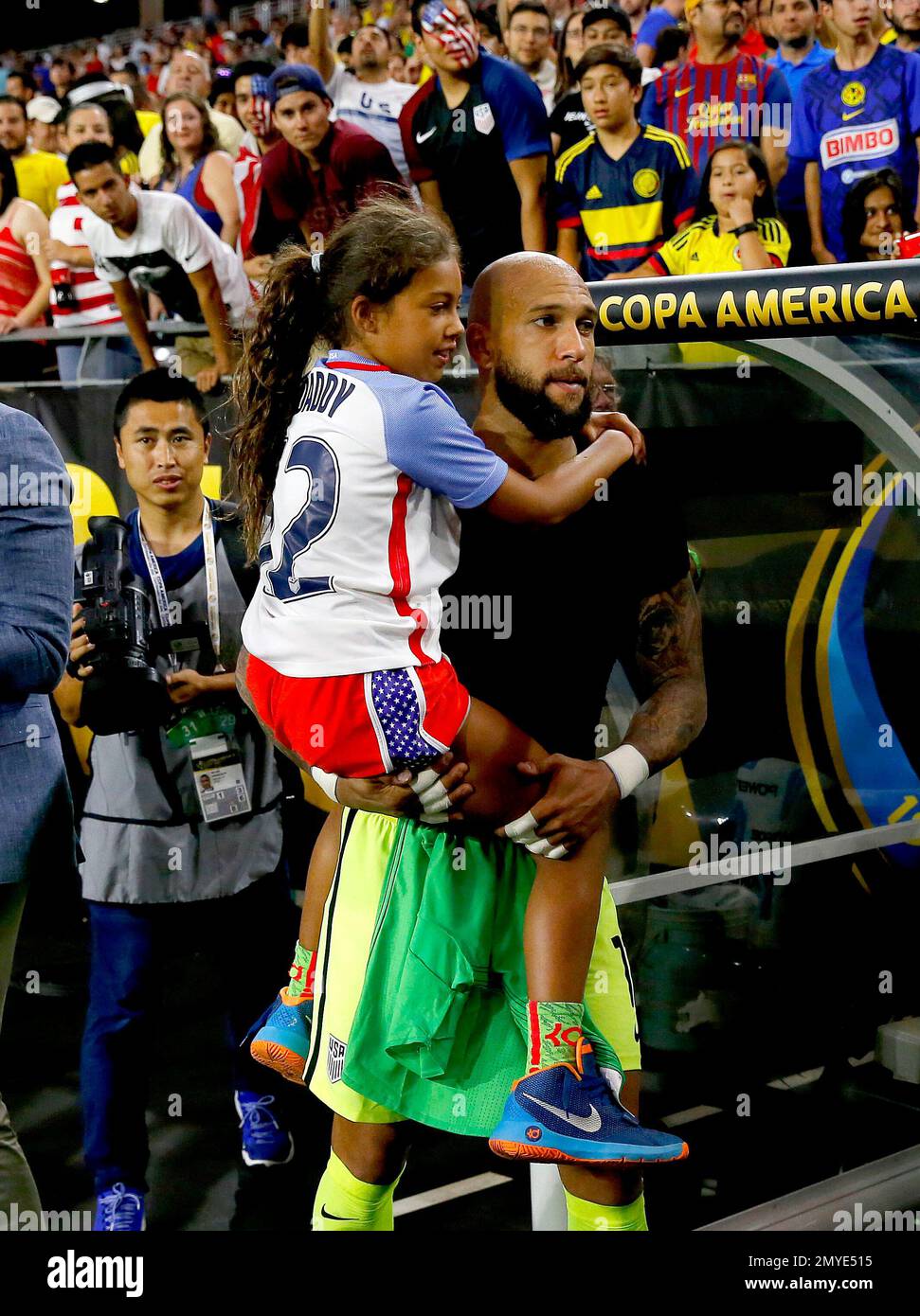 United States goalkeeper Tim Howard carries his daughter, Alivia Howard ...