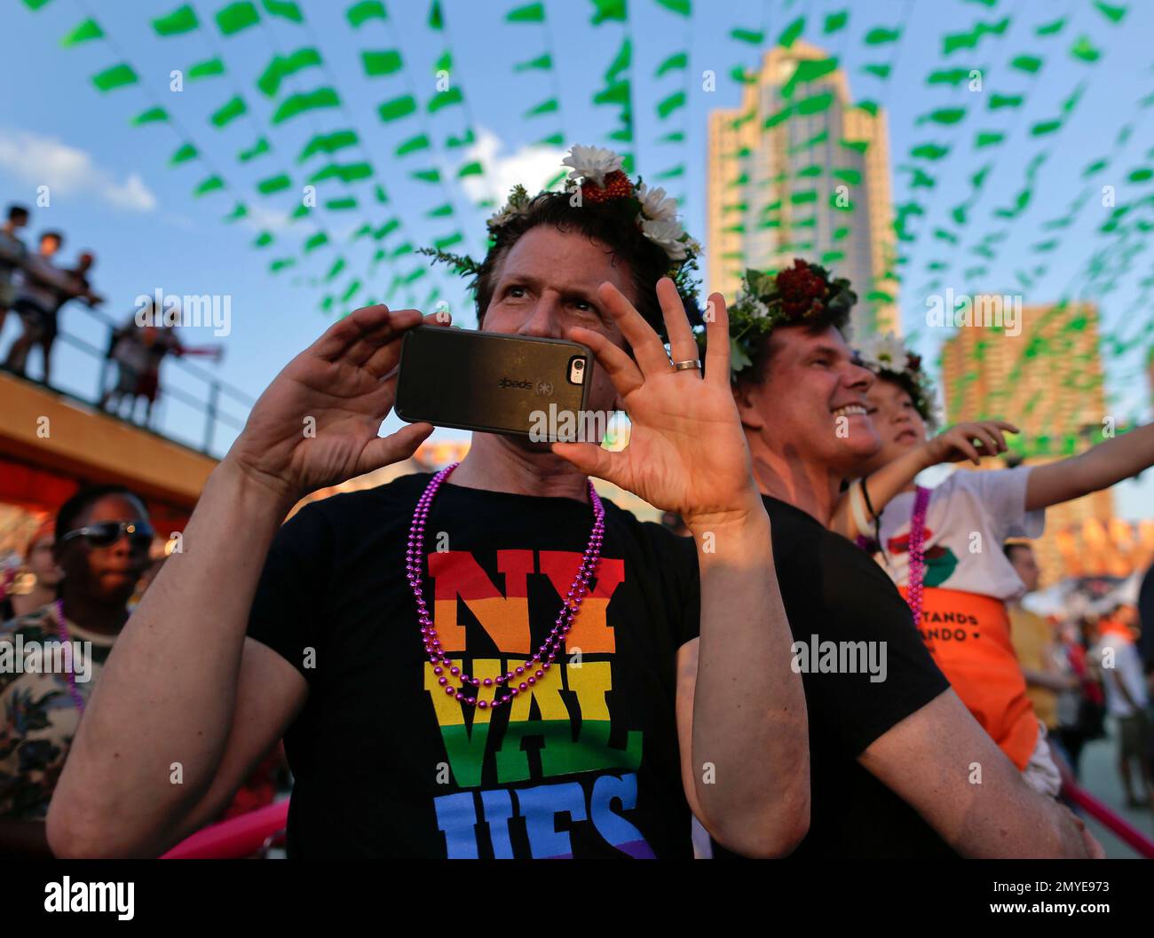 Gary Spino, left, takes photos of the Gay Pride Rally while attending ...