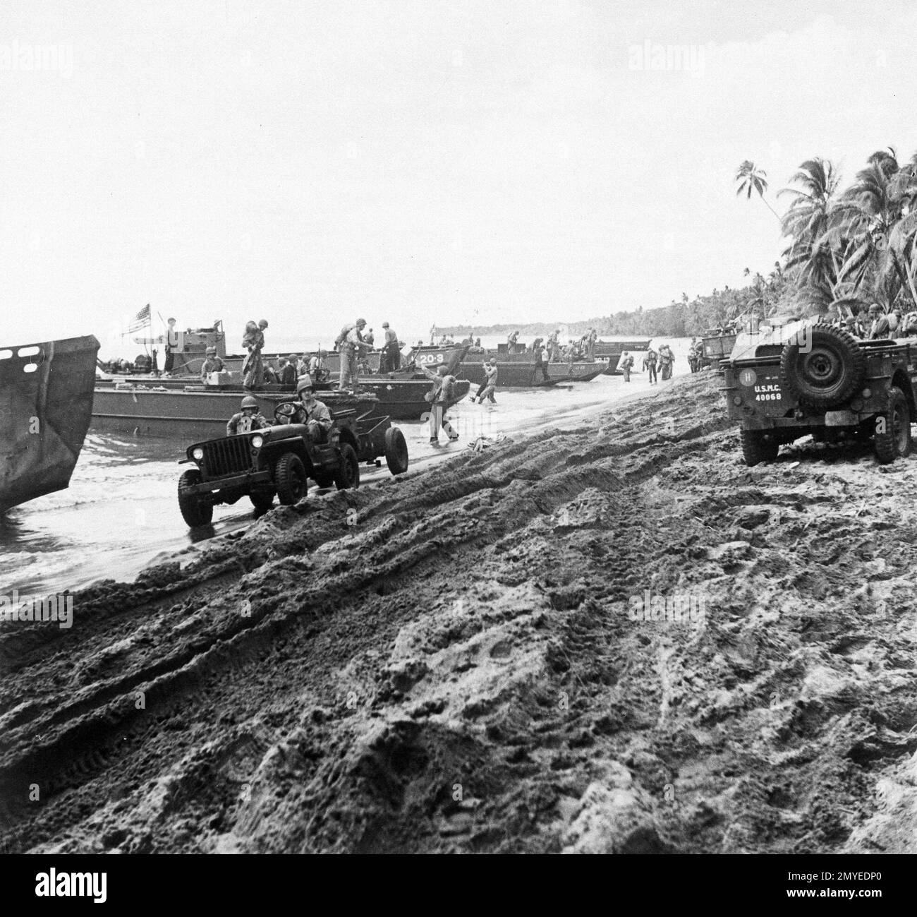 U.S. Marines ride an amphibious tank as it reaches shore and starts to ...