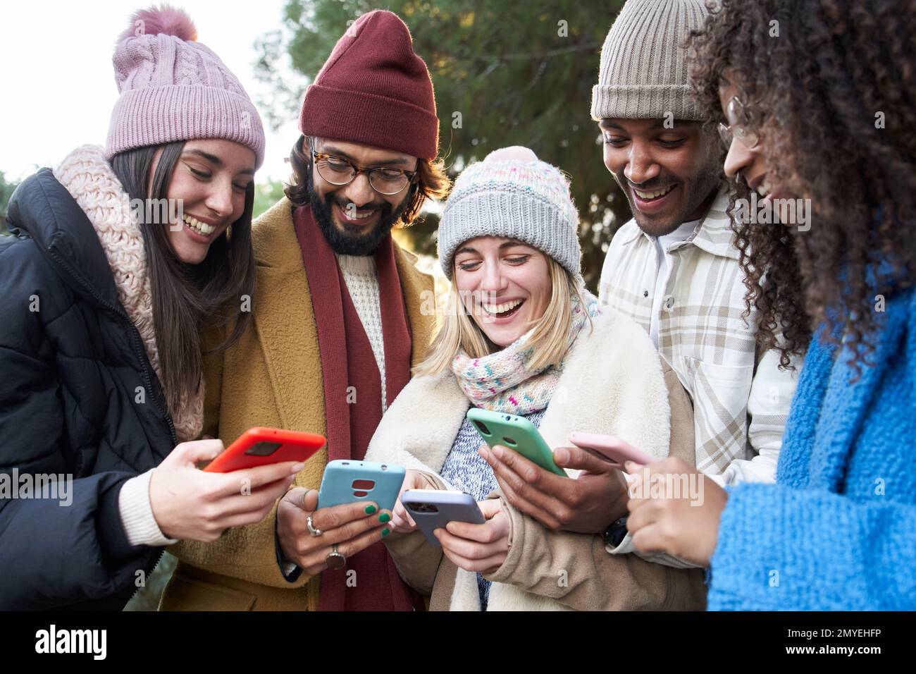 Group of young mixed race friends with mobile phones. Technology ...