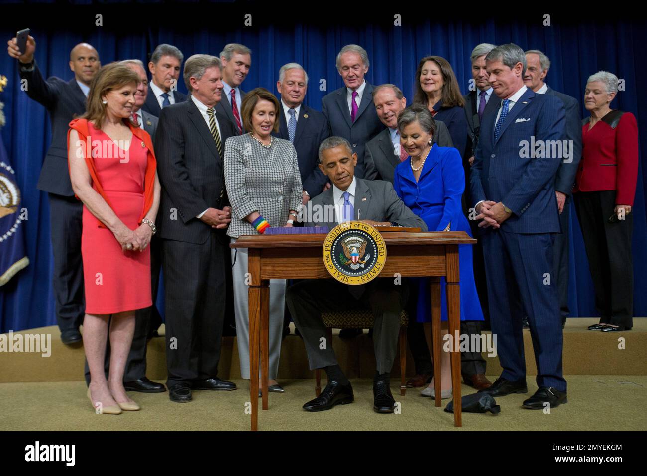 President Barack Obama, surrounded by members of Congress, signs bill H ...