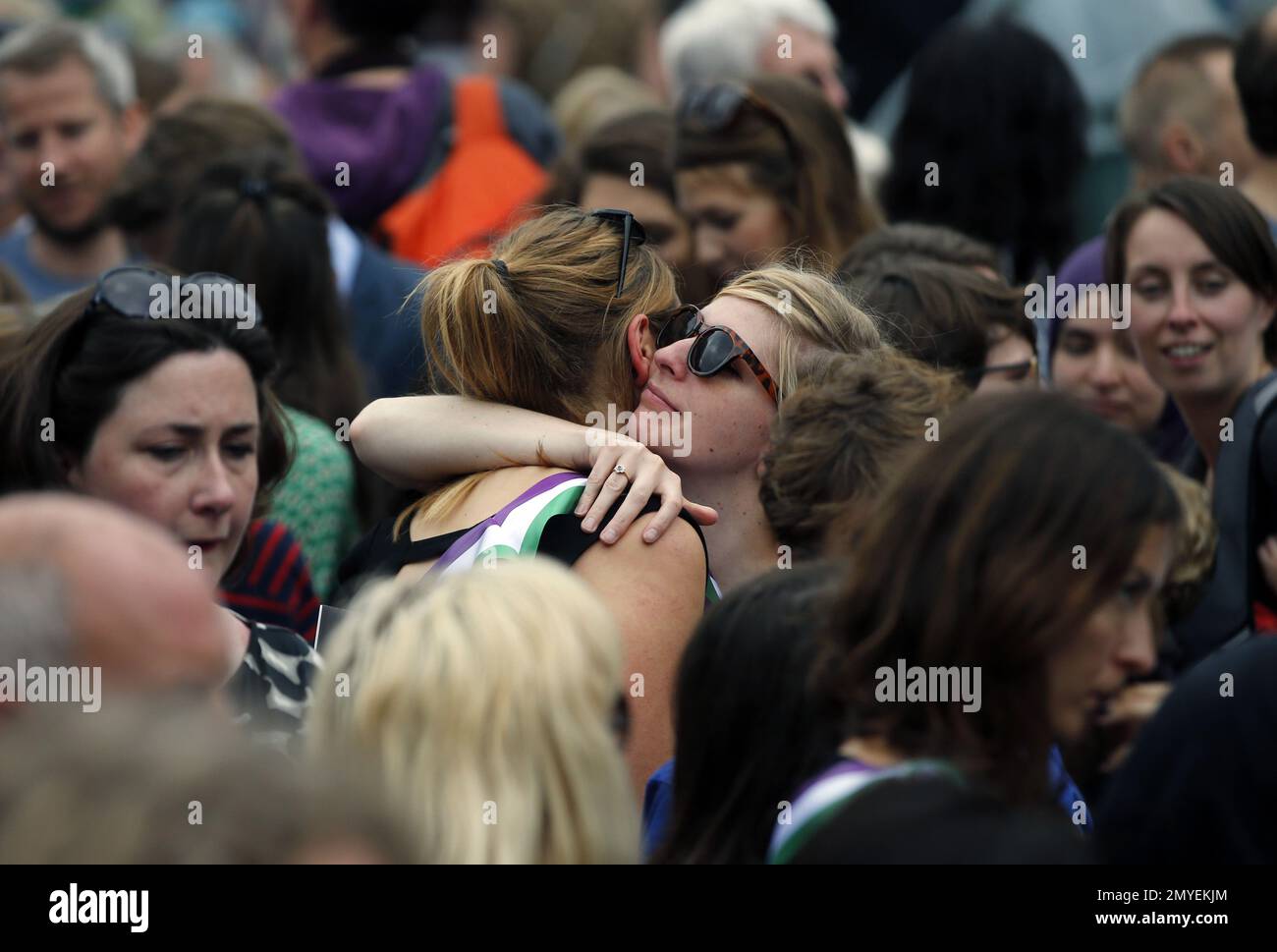People hug in the crowds during a gathering to celebrate the life of ...