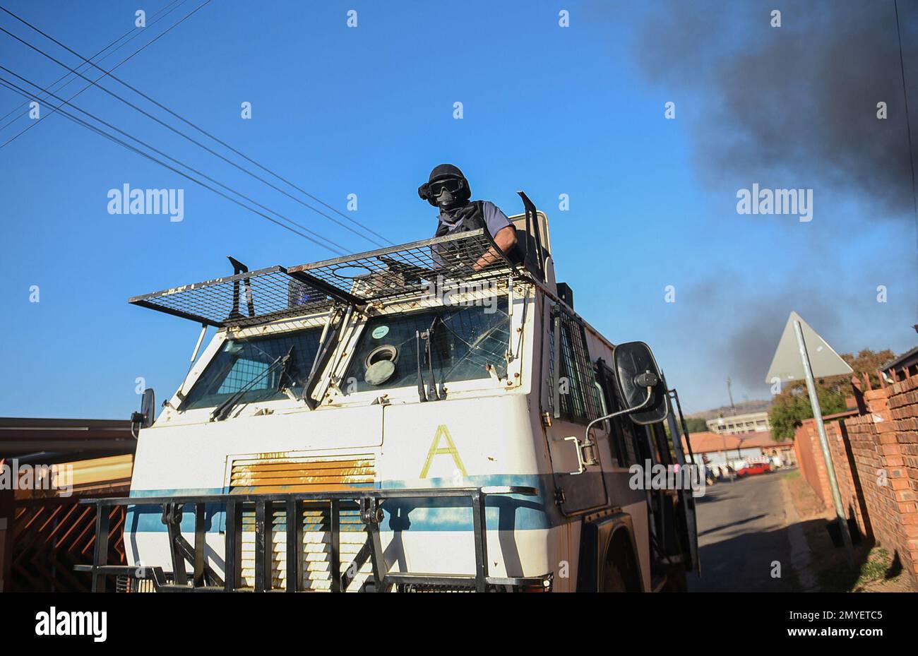 A police vehicle patrols a street as residents riot, in Atteridgeville ...