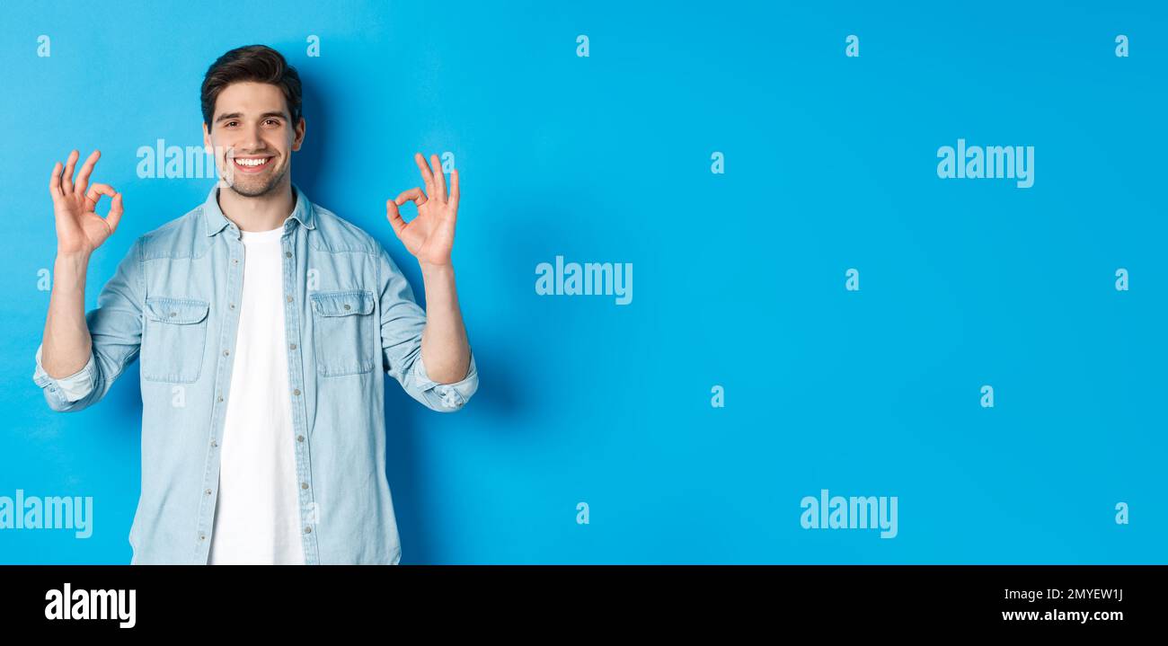 Confident smiling adult man, showing ok signs and looking pleased, like ...