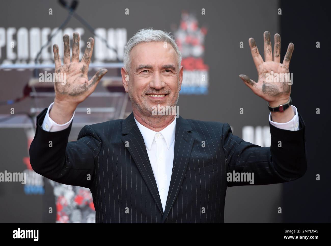 Roland Emmerich shows off his hands after placing them in cement during ...