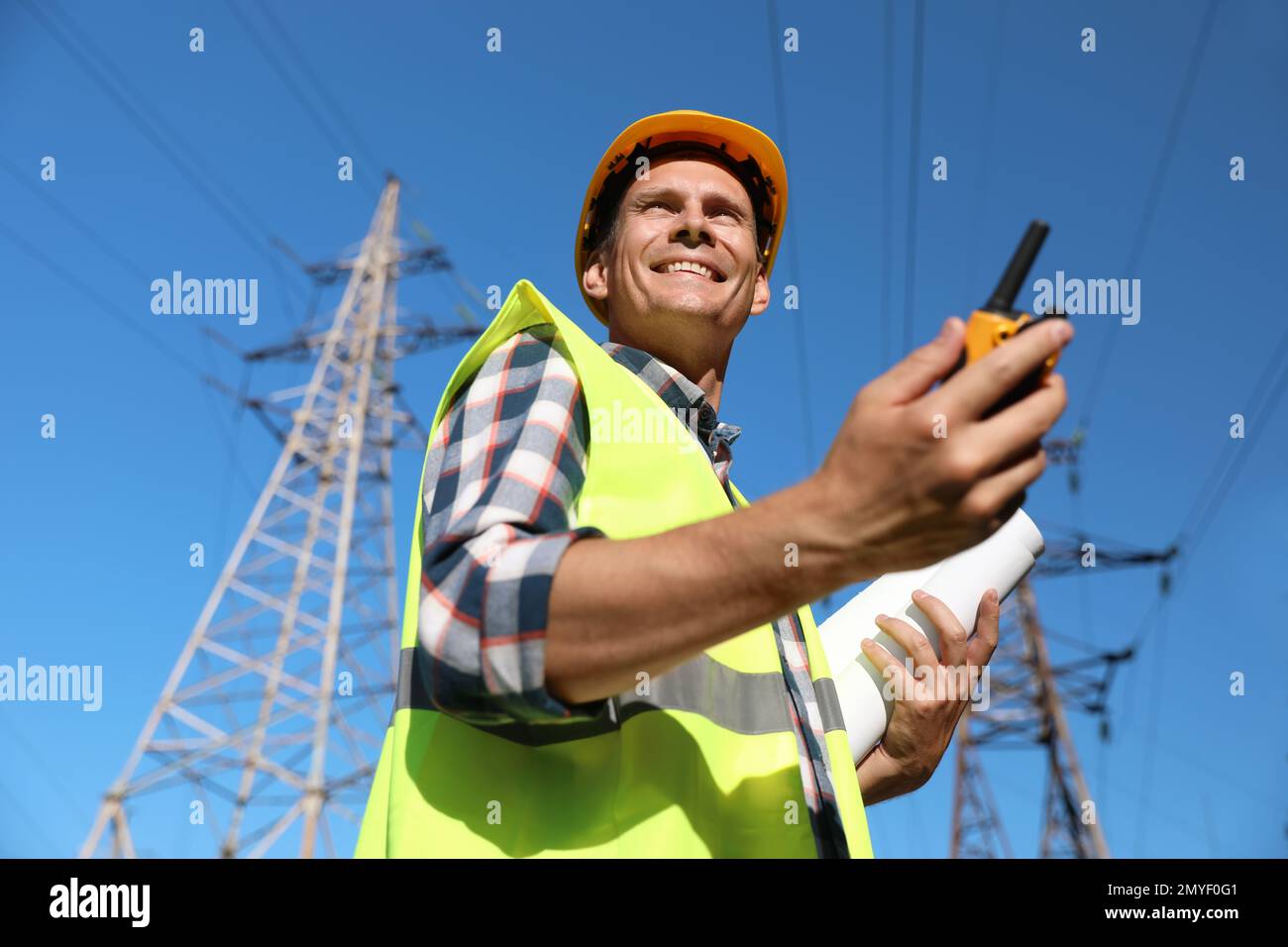 Professional electrician with portable radio station near high voltage ...
