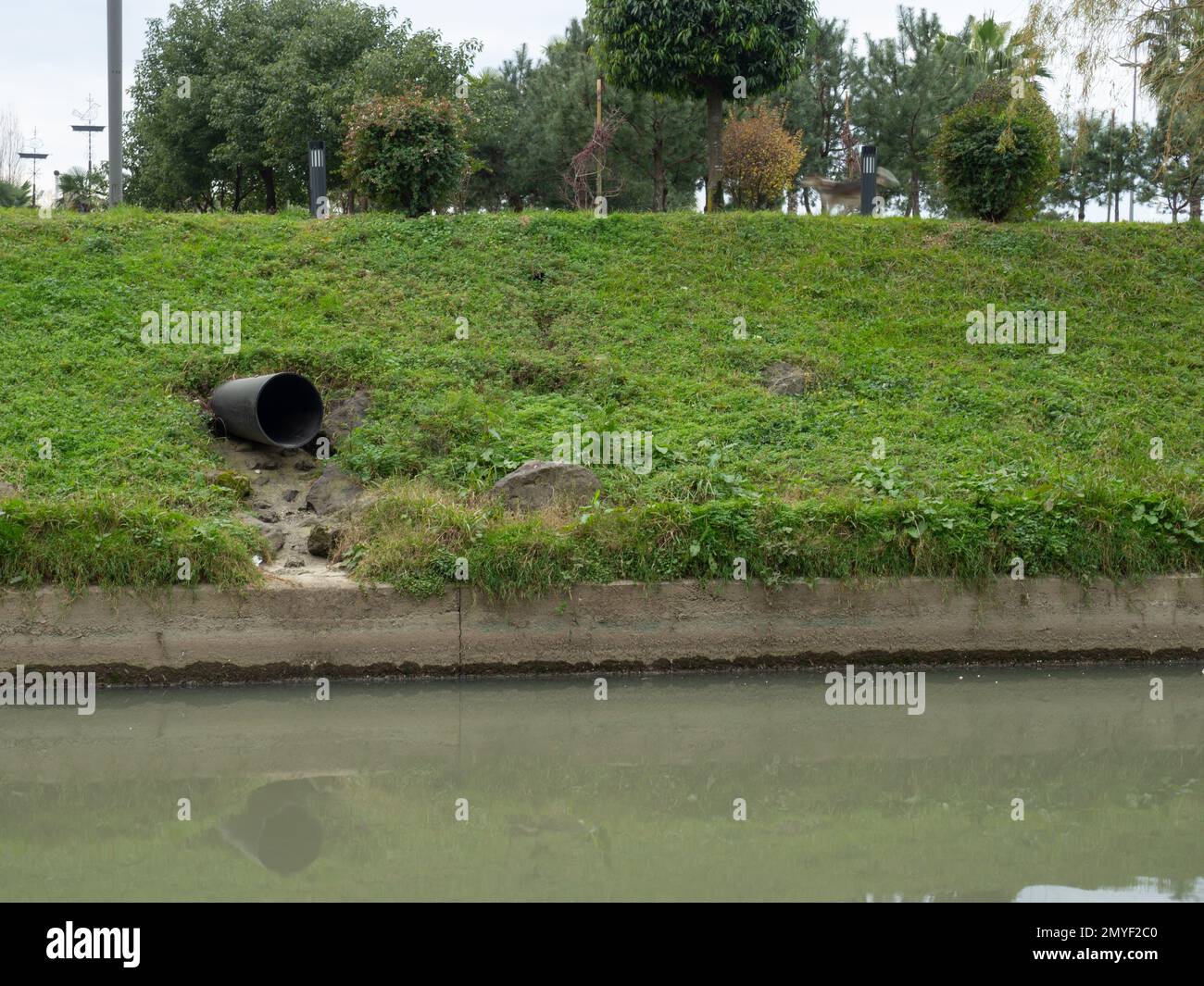 The pipe sticks out of the slope. Drainage of water from stormwater ...