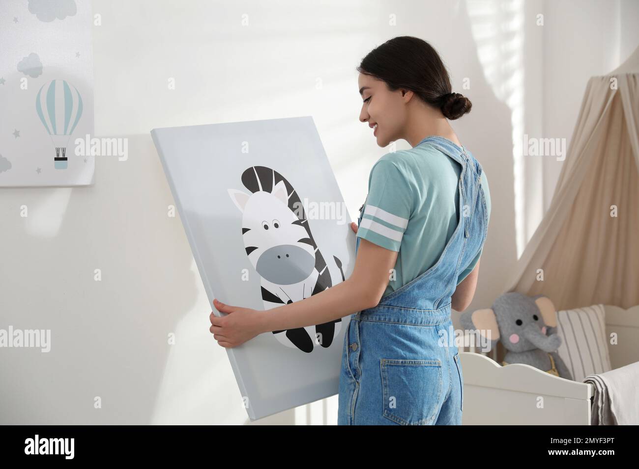 Decorator with picture near white wall. Children's room interior design ...