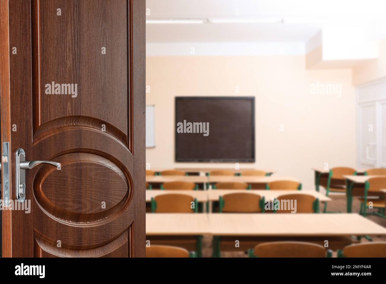 Wooden door open into modern empty classroom Stock Photo - Alamy