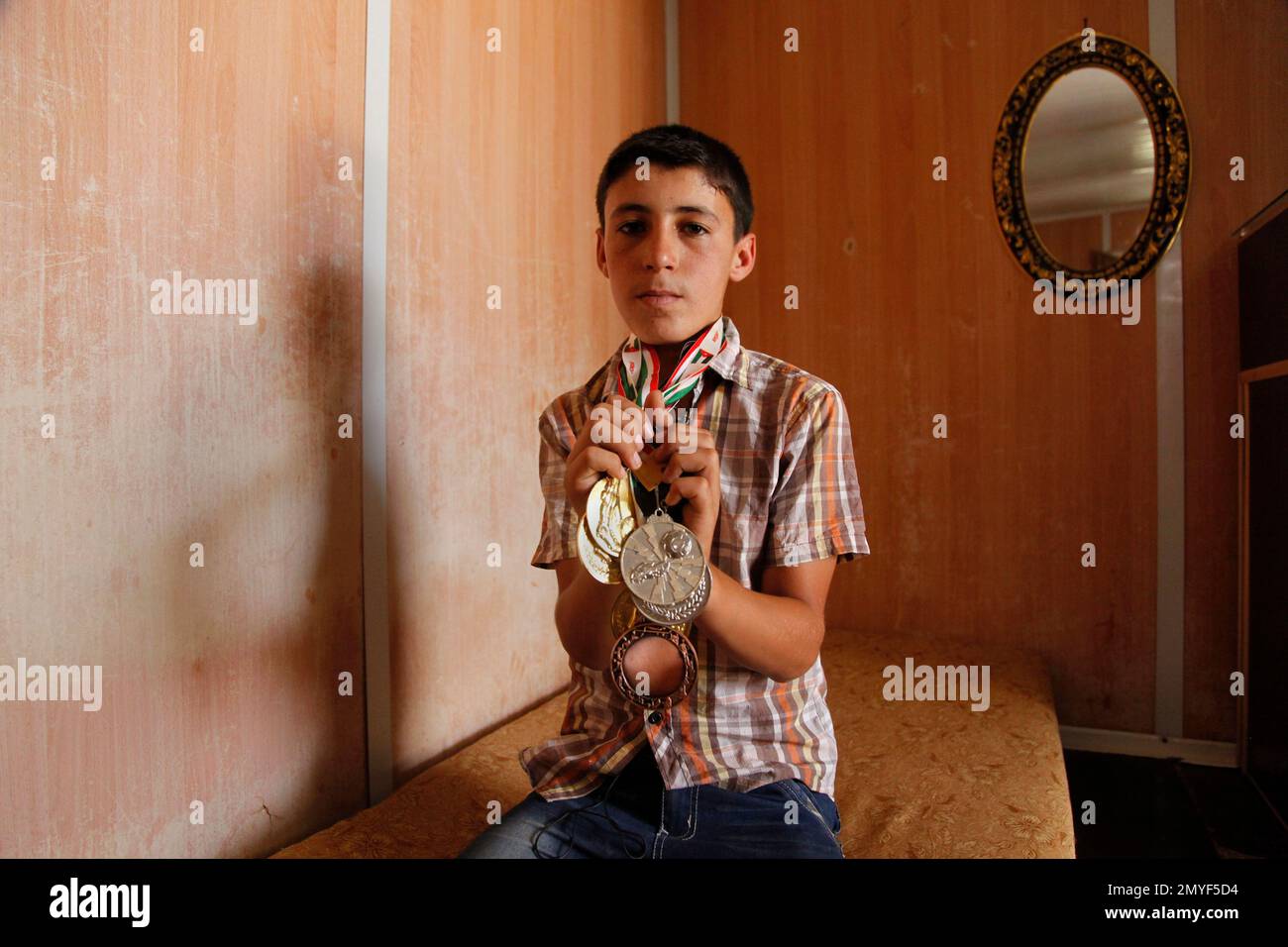 Ayman Ashara, 13, holds gold, silver and bronze medals he's earned ...