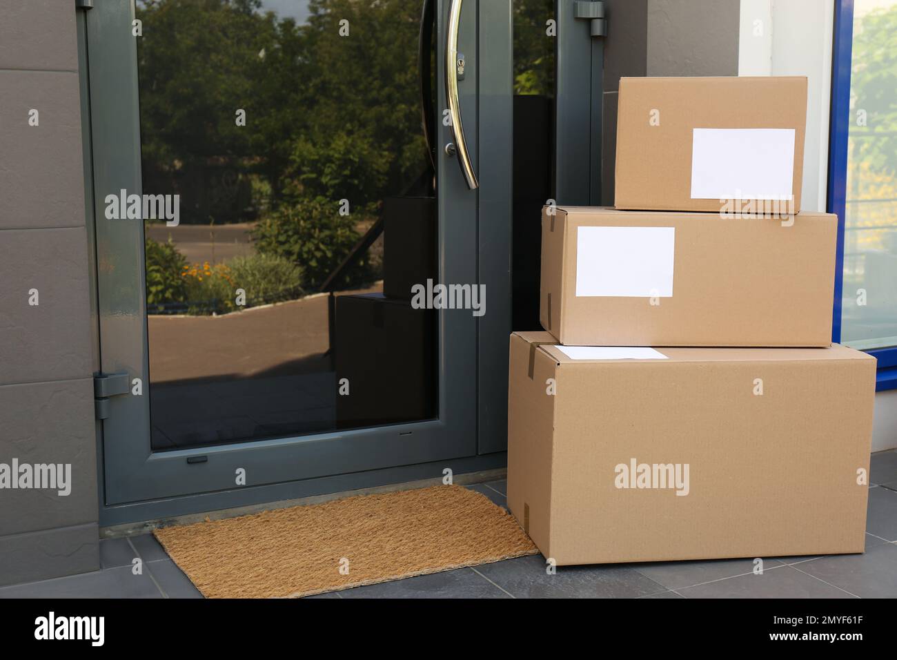Cardboard boxes near door. Parcel delivery service Stock Photo - Alamy