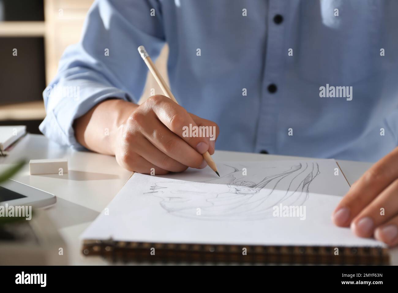 Man drawing portrait with pencil in notepad at table, closeup Stock ...