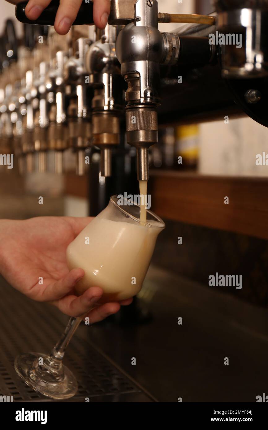 Bartender pouring fresh beer into glass in pub, closeup Stock Photo - Alamy