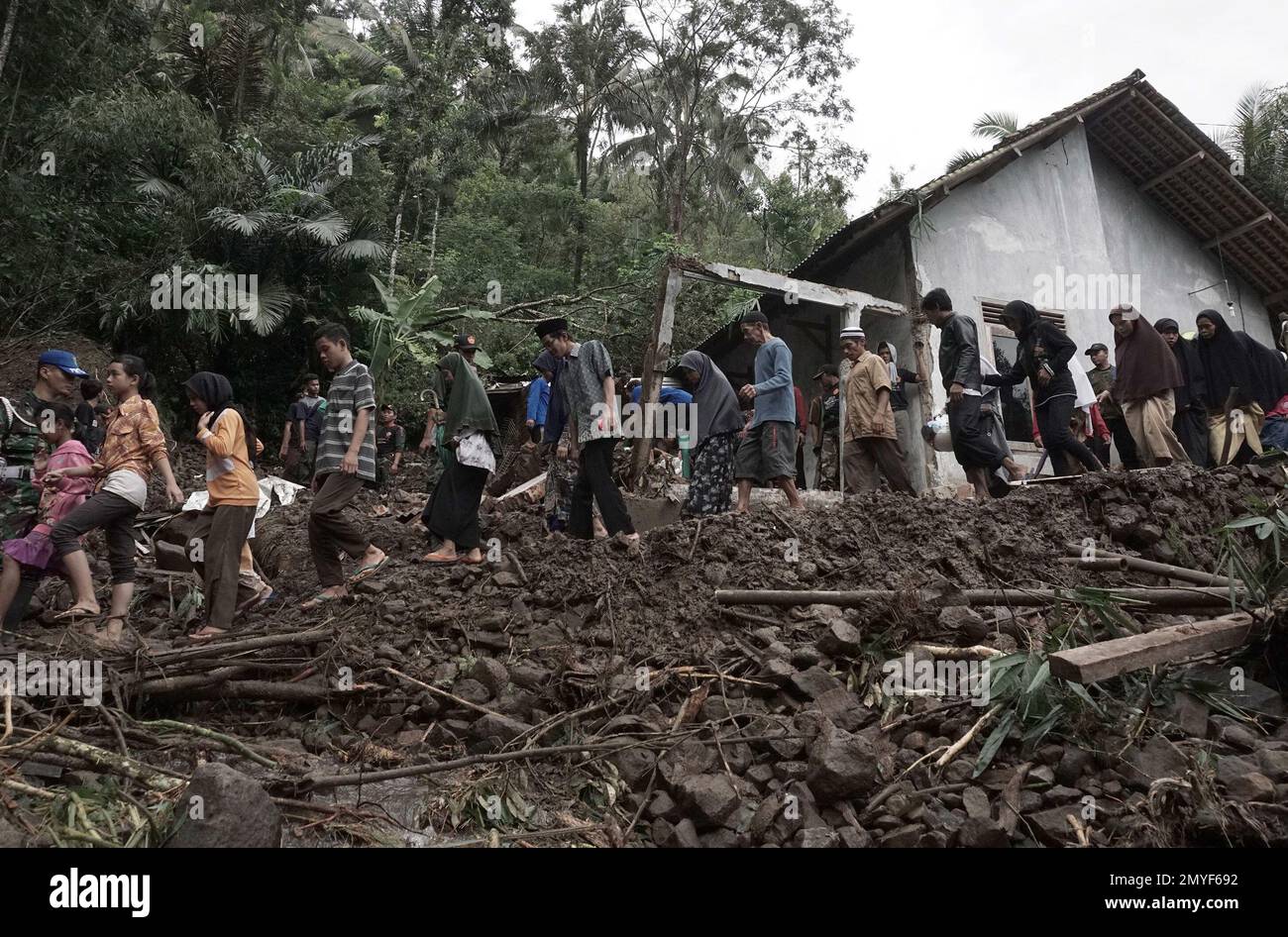 Villagers walk through the area affected by landslides in Banjarnegara ...