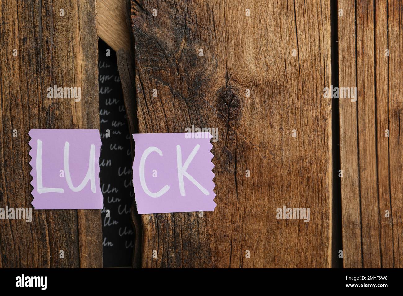 Torn card with word LUCK on wooden background. Space for text Stock ...
