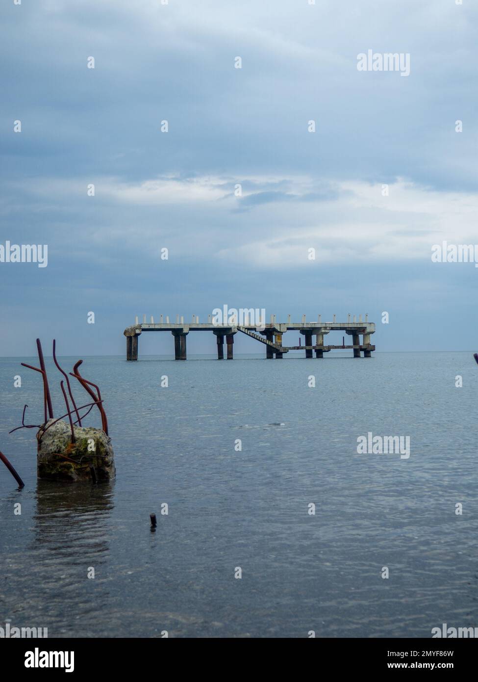 Reinforced concrete sticking out of the water. Remains of an old bridge ...