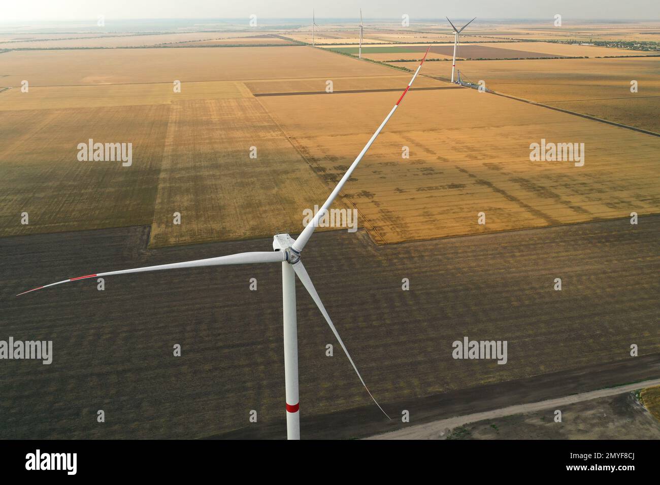 Modern windmill in field, space for text. Energy efficiency Stock Photo ...