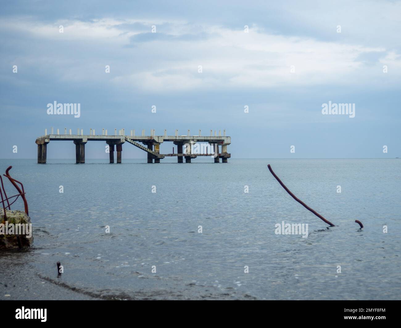 Reinforced concrete sticking out of the water. Remains of an old bridge ...
