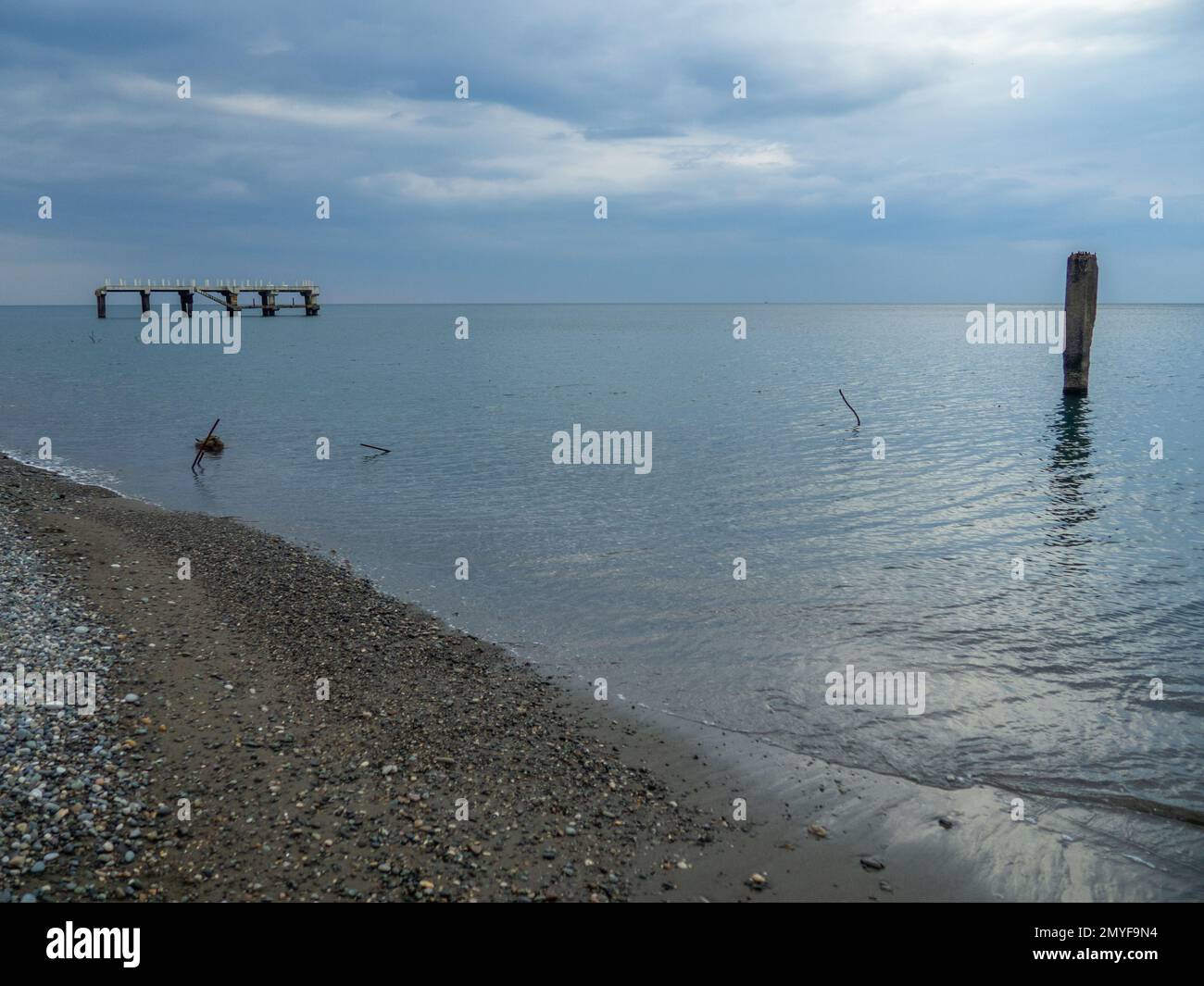 Reinforced concrete pile sticking out of the water. Remains of an old ...