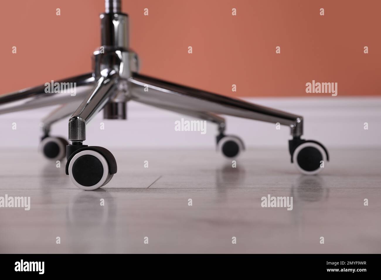 Modern office chair with wheels on wooden floor, closeup Stock Photo ...